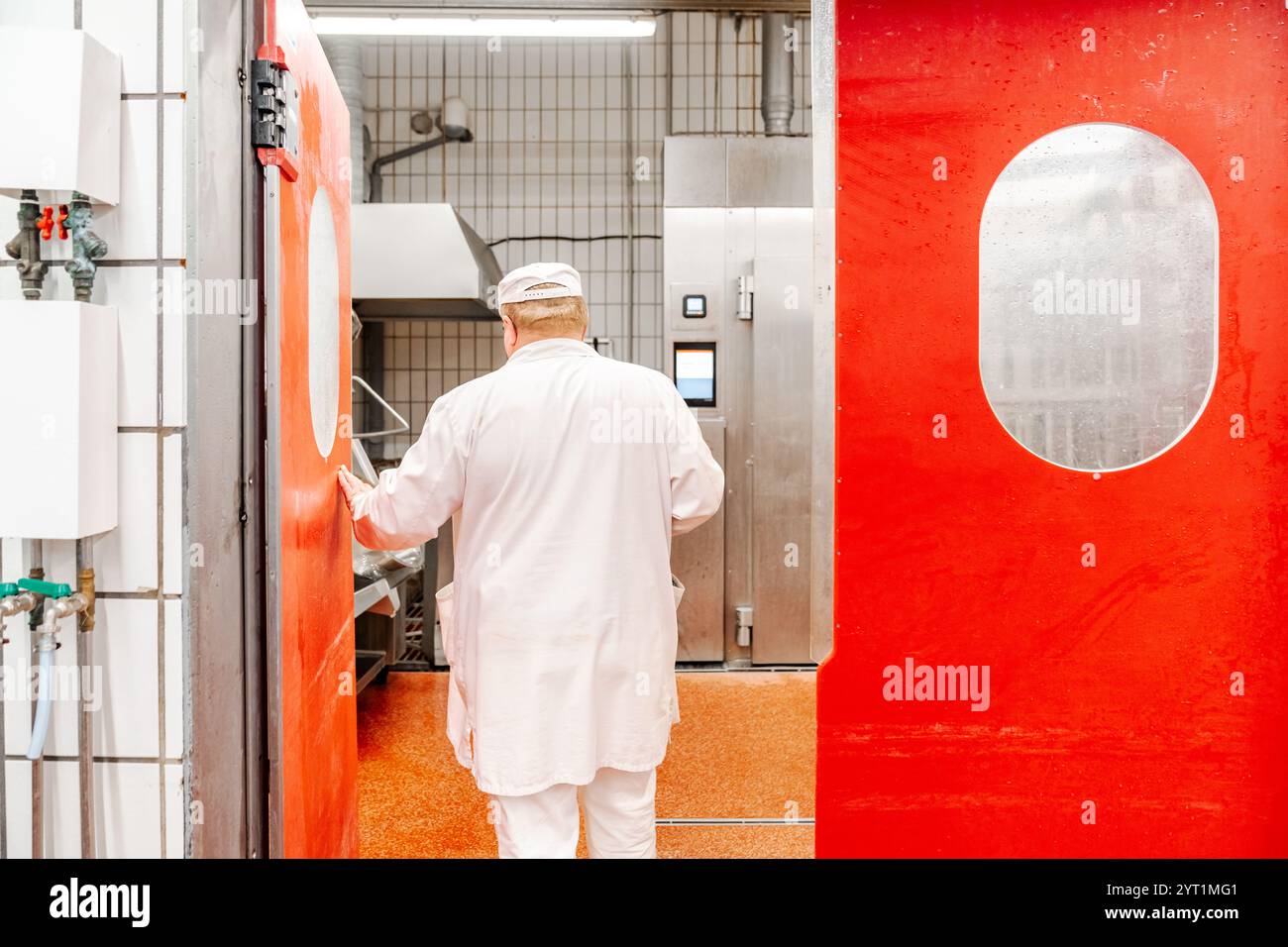 Butcher opening red door in food processing plant Stock Photo - Alamy