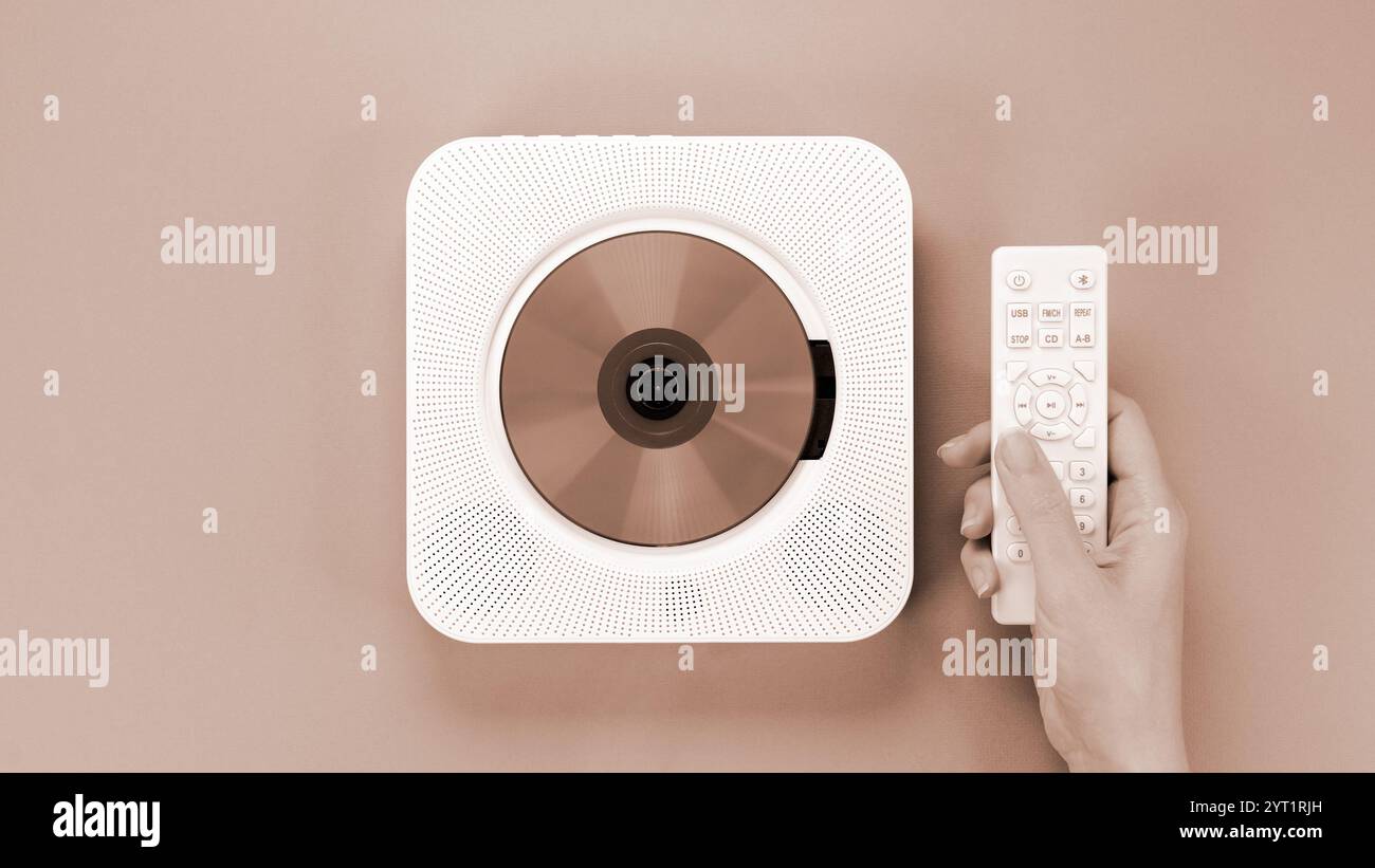 Hands holding stylish white portable compact CD player cd disc playing ...