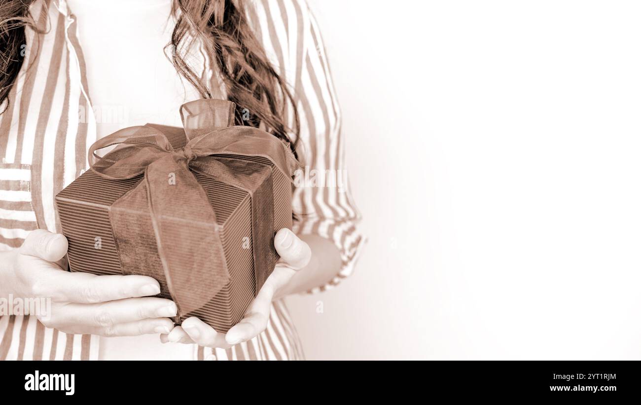 Attractive woman holding a gift box with a red ribbon, on white ...