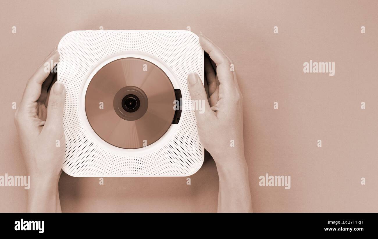 Hands holding stylish white portable compact CD player cd disc playing ...