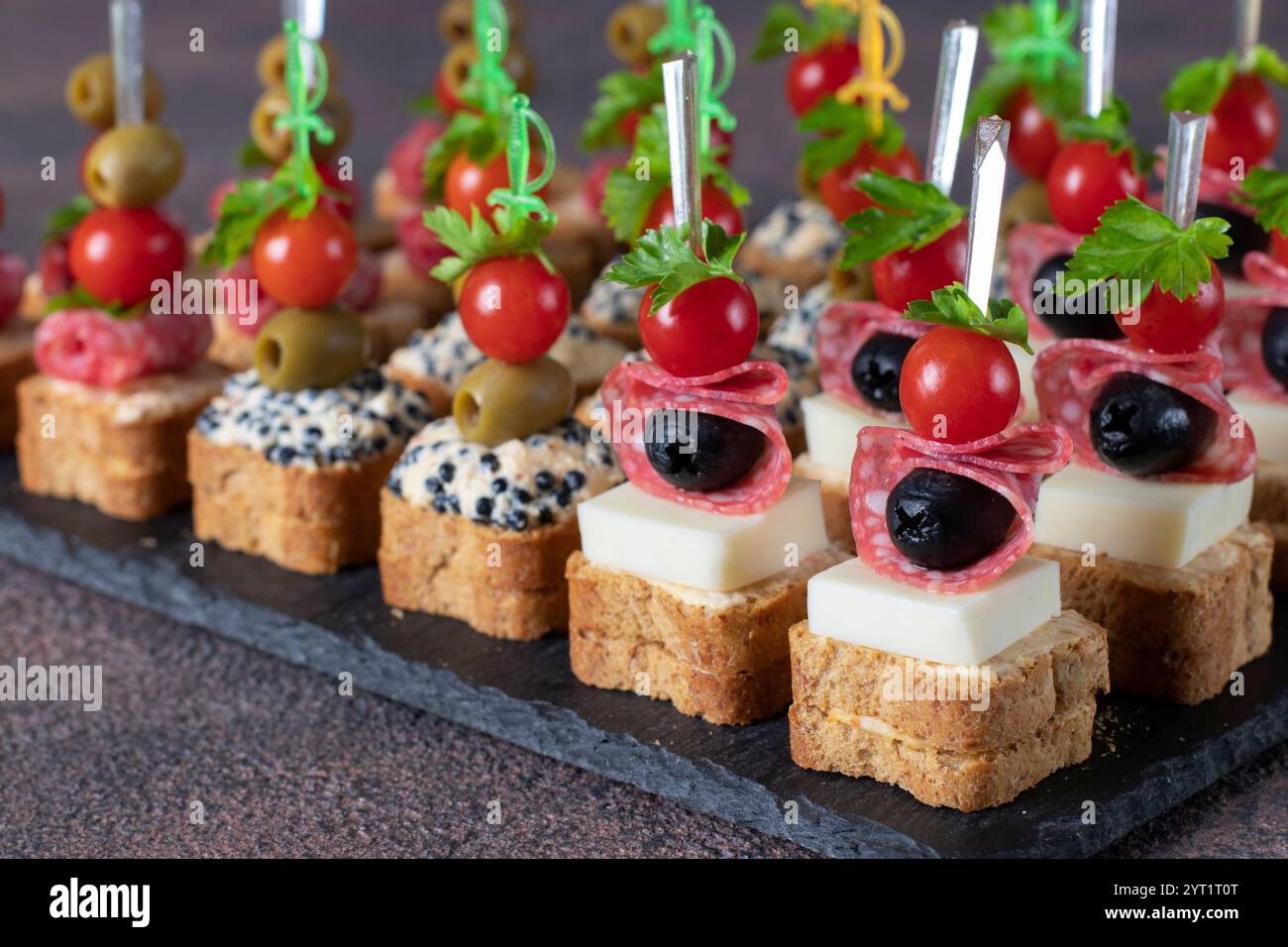 Assortment of canapes with cherry tomatoes, sausage, cheese, olives and ...