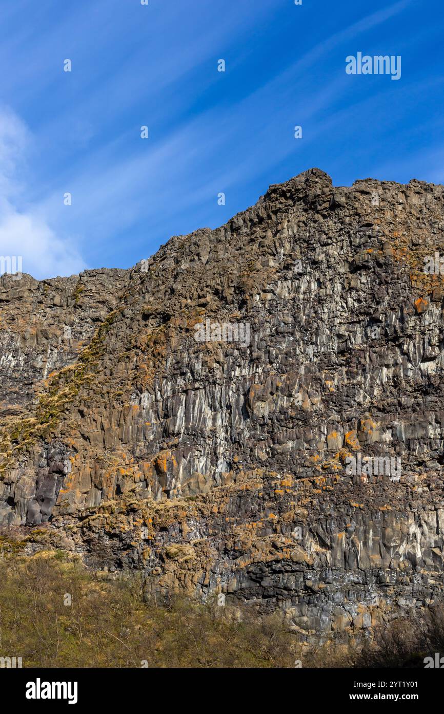 Vertical volcanic rock formations and cliffs overgrown with moss in ...