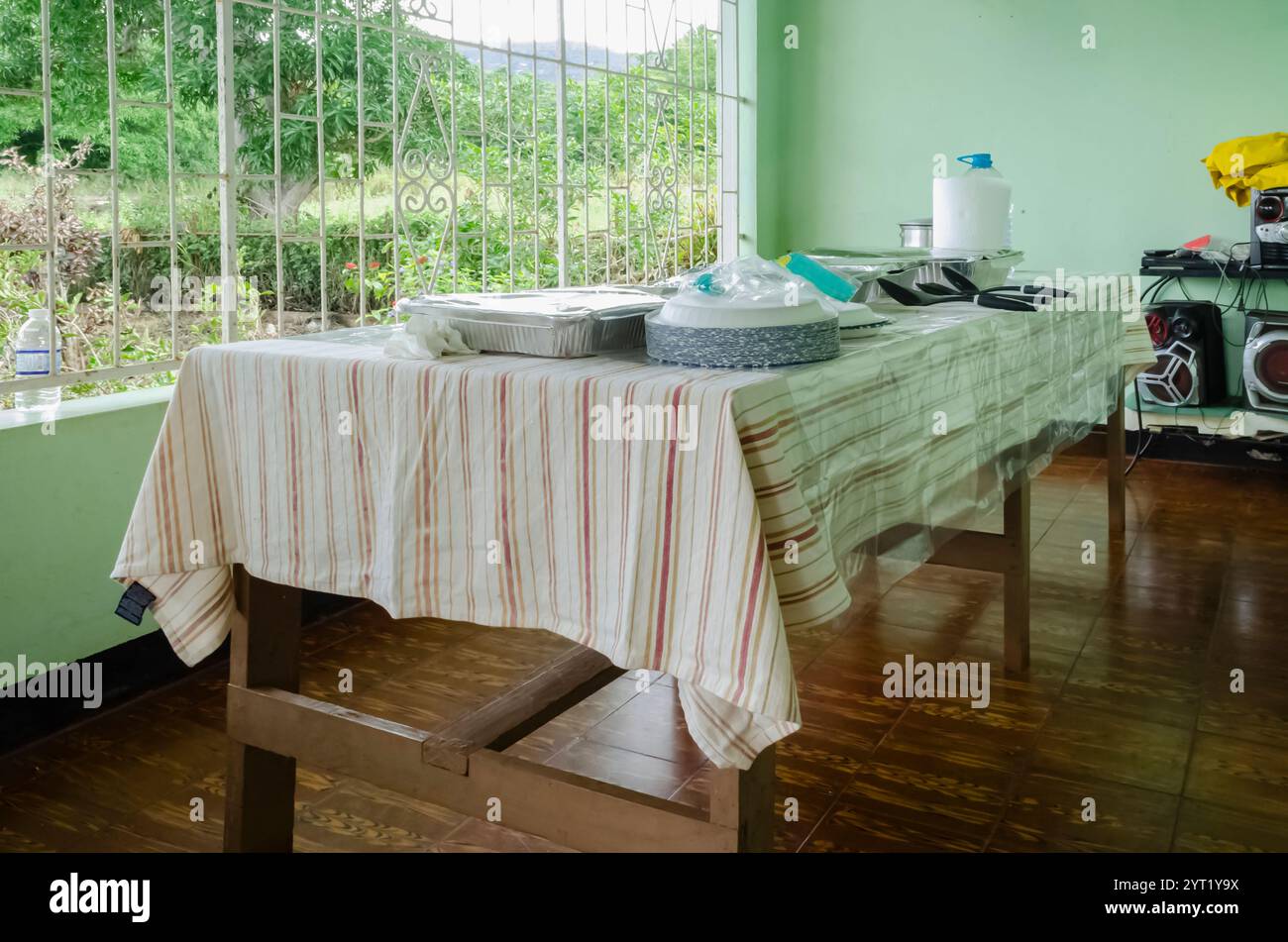 Food in a pot and aluminum Pans are laid out on a table with a role of ...