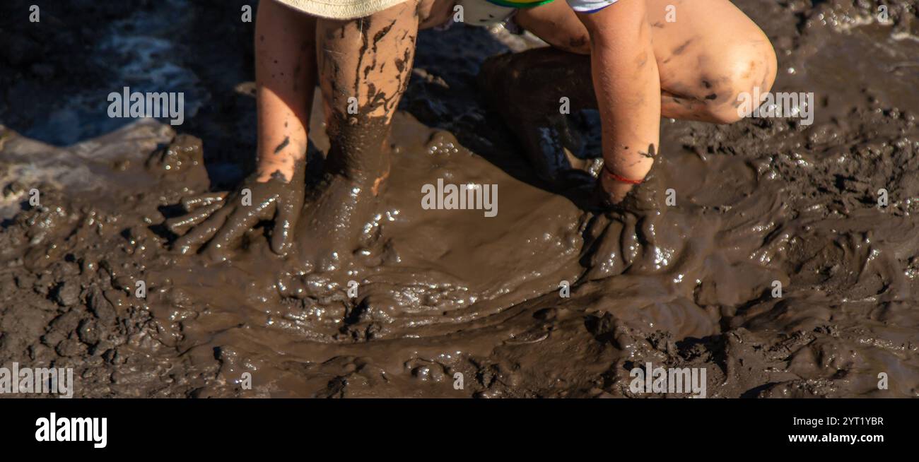 Child playing in mud. Selective focus. Kid Stock Photo - Alamy