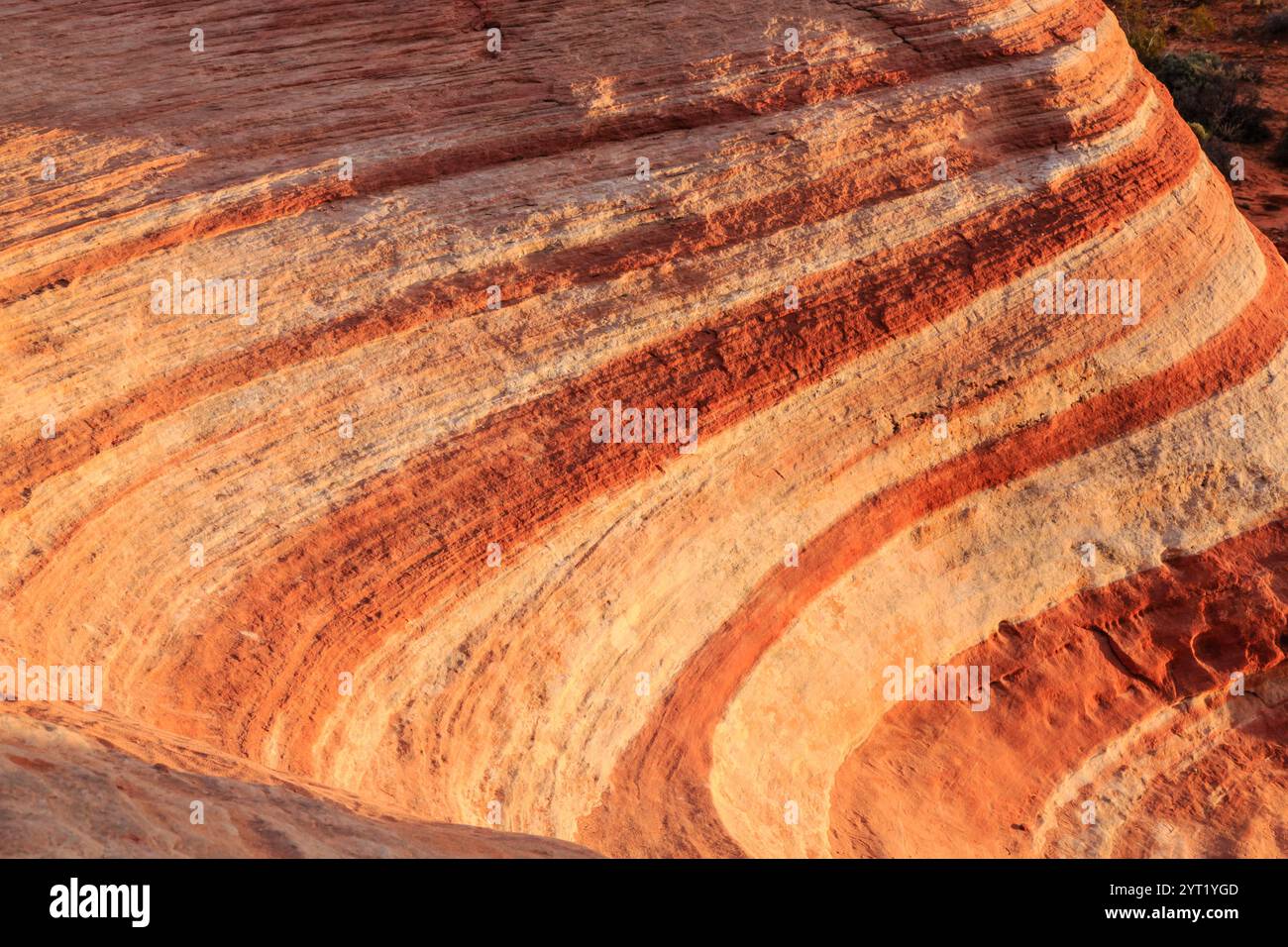 A rocky, red hill with a series of ridges and valleys. The colors are ...