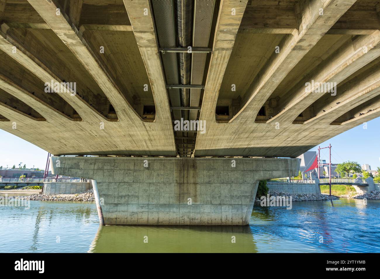 A bridge with a concrete structure and a waterway underneath. The ...
