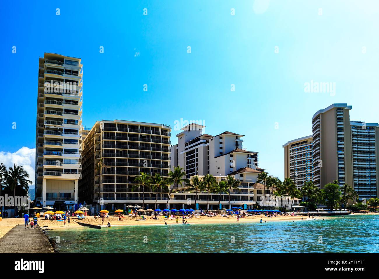 A beach with a large hotel complex in the background. The hotel complex ...