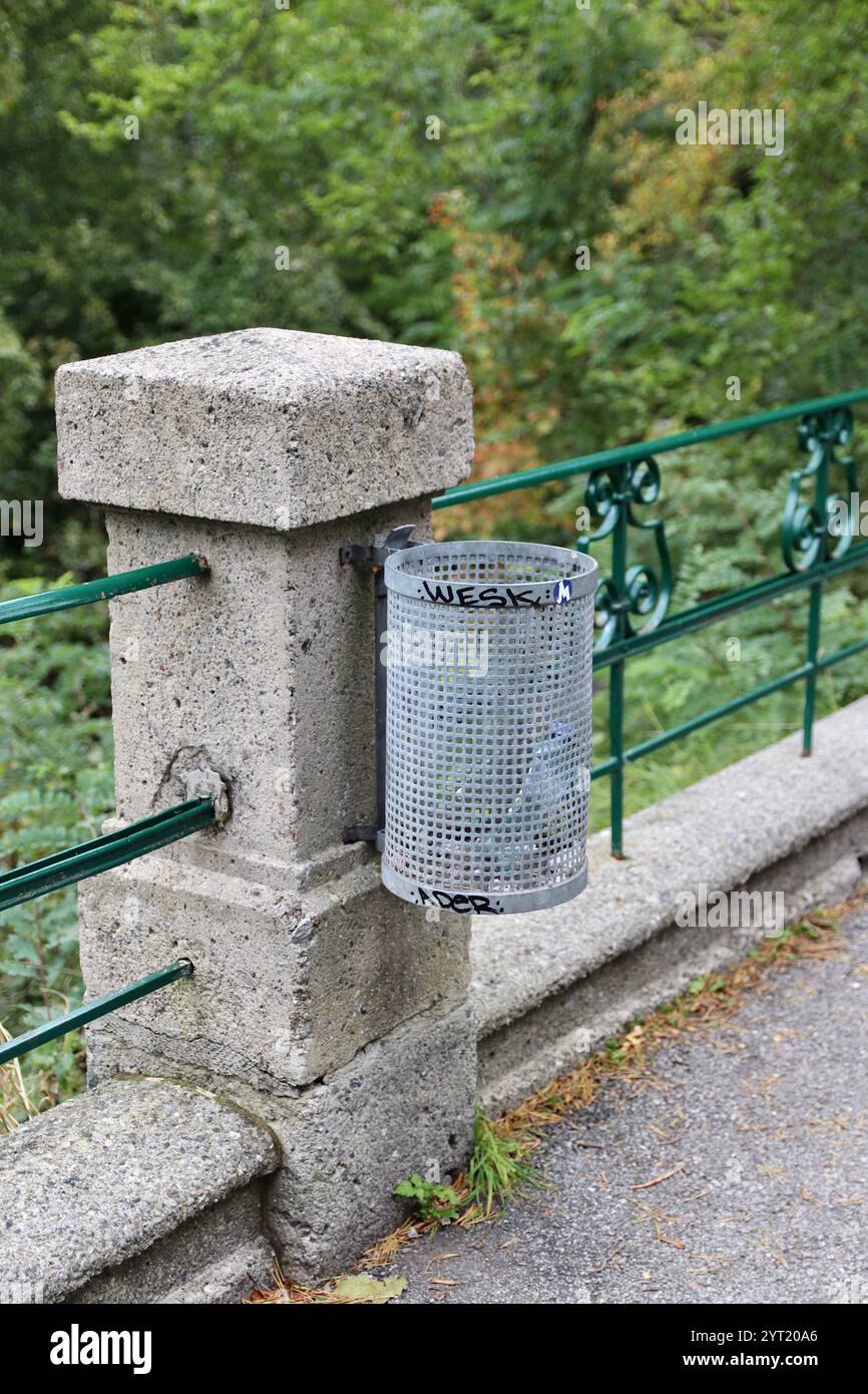 Urban Trash Bin Attached to Stone Post on Scenic Bridge Railing in ...