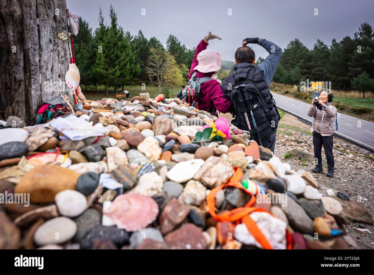 Pilgrim on the Camino de Santiago offering votive stones and offerings ...