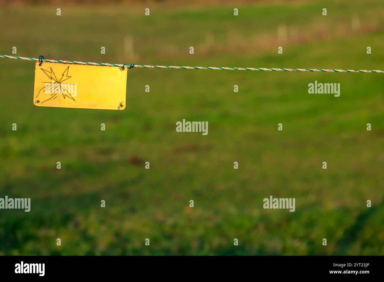 Electric fencing panel in athe french countryside. The sign warns ...