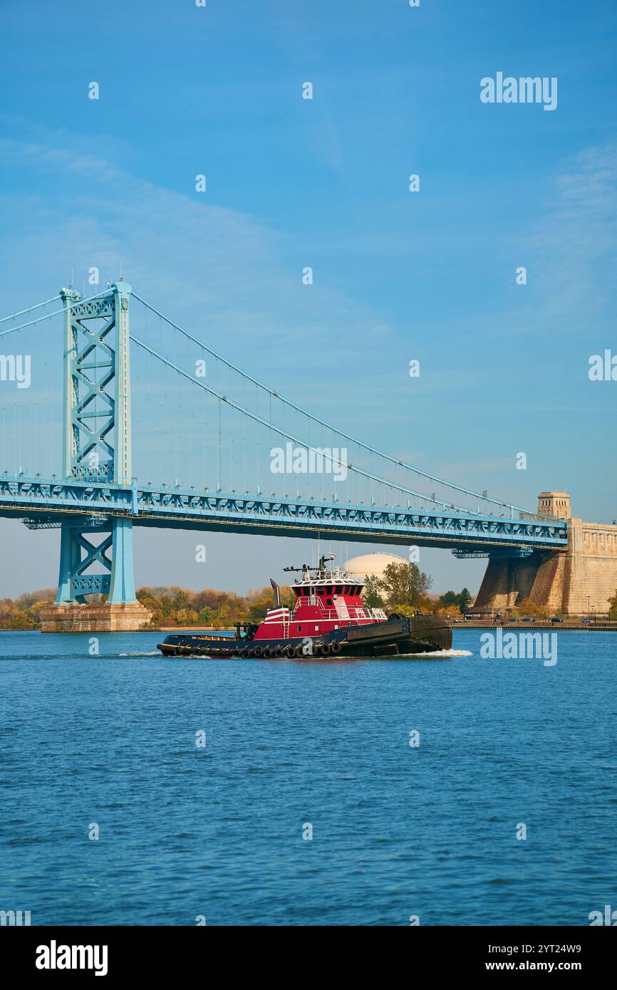 tugboat sails under a large bridge Stock Photo - Alamy