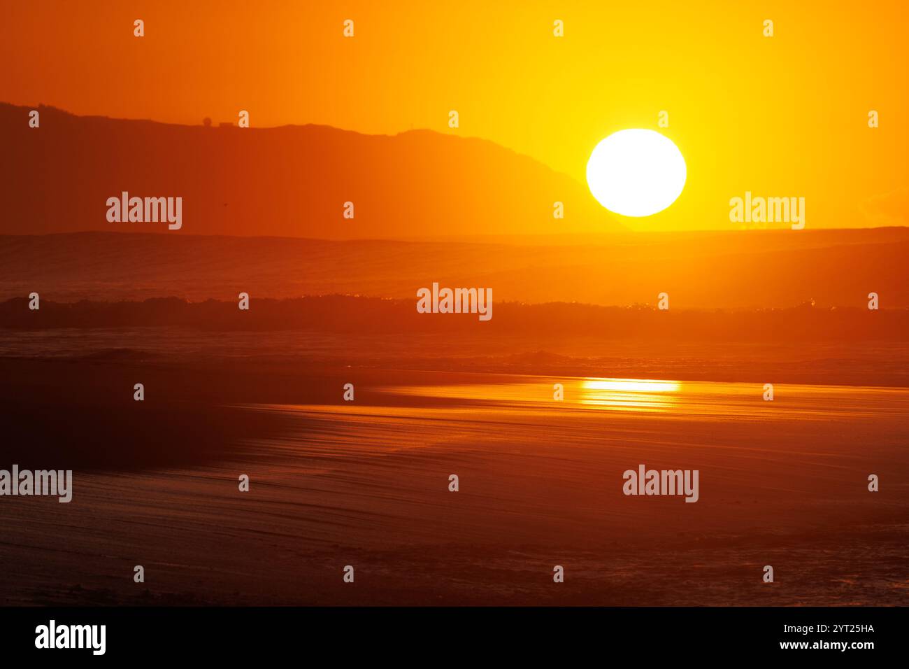 Dec 1 2024. Ehukai Beach Park, HI. The sun sets over Kaena Point on the ...