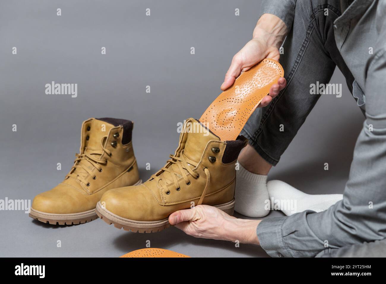 Close up of man hands putting pair of orthopedic insoles inside the ...