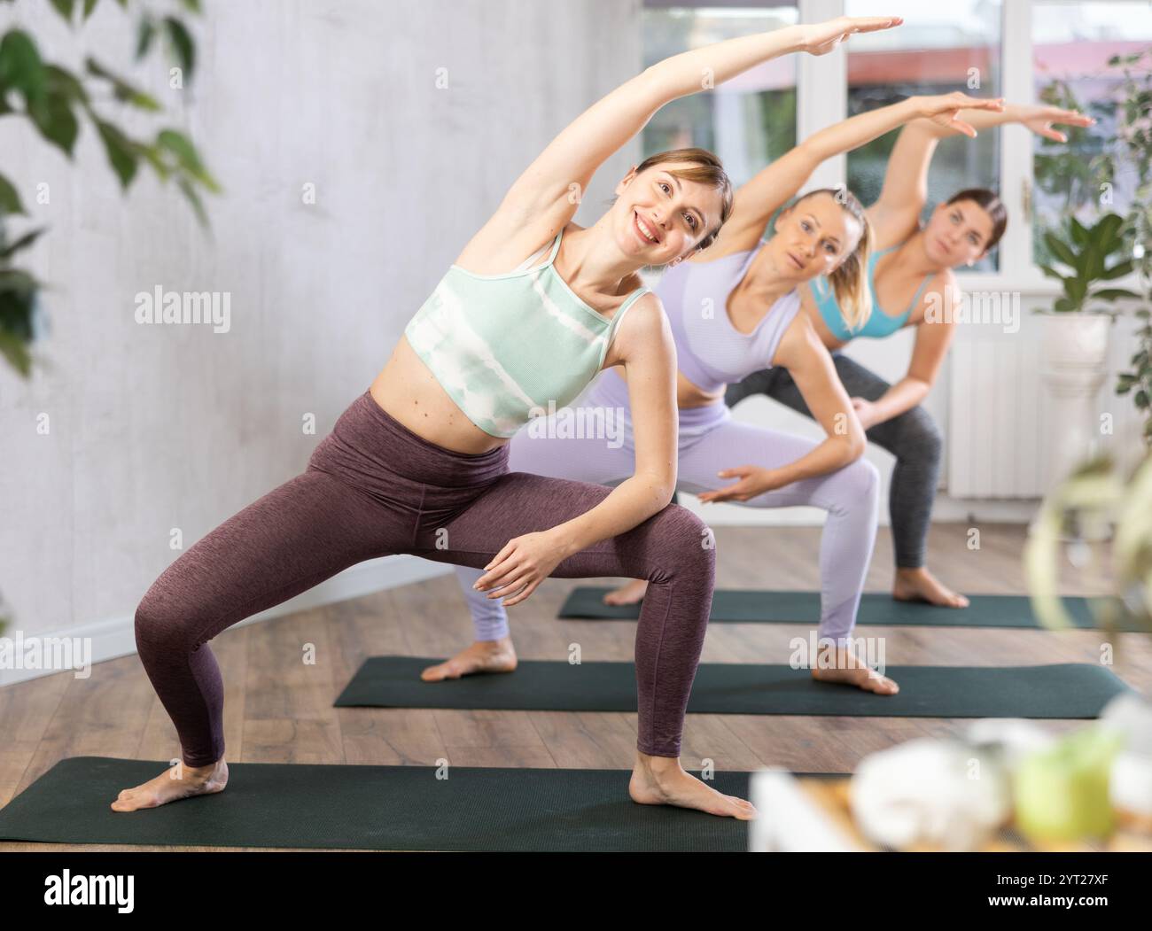 Group of active women practice various yoga poses Stock Photo - Alamy