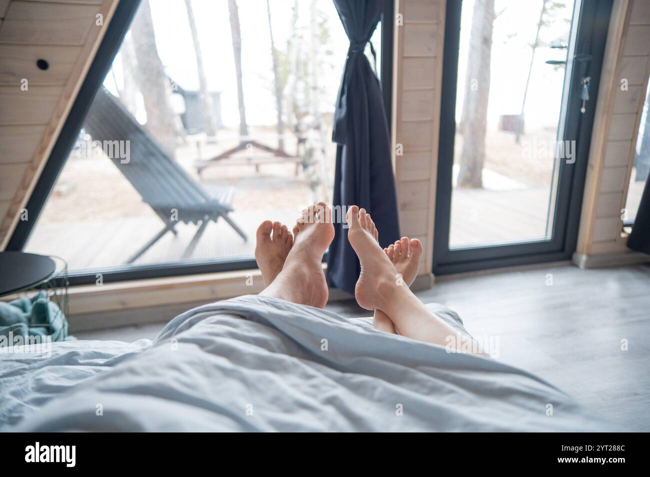 The feet of a married couple sticking out from under the blanket in a ...