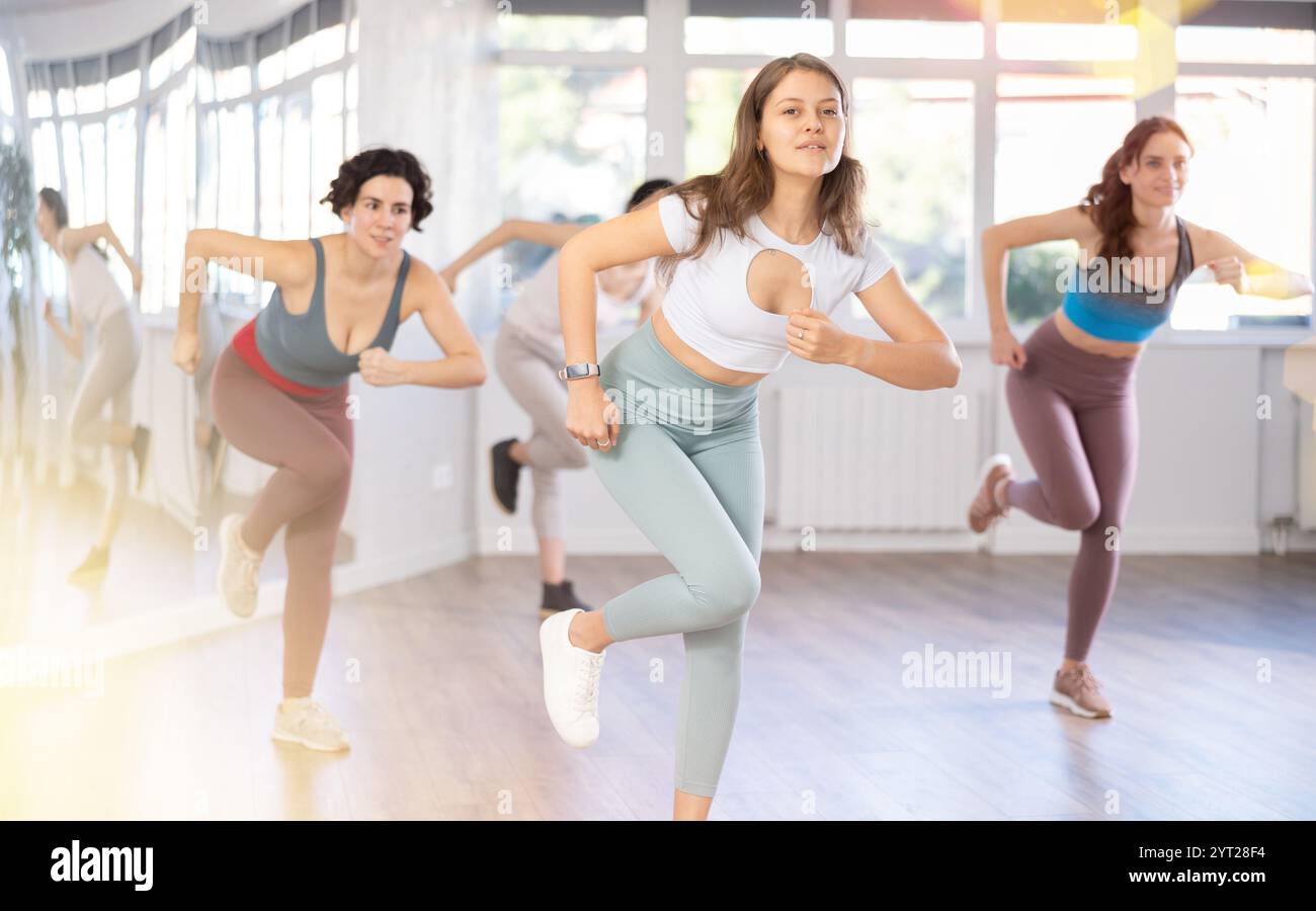 Young female teacher conducts modern dance lessons for group of girls ...