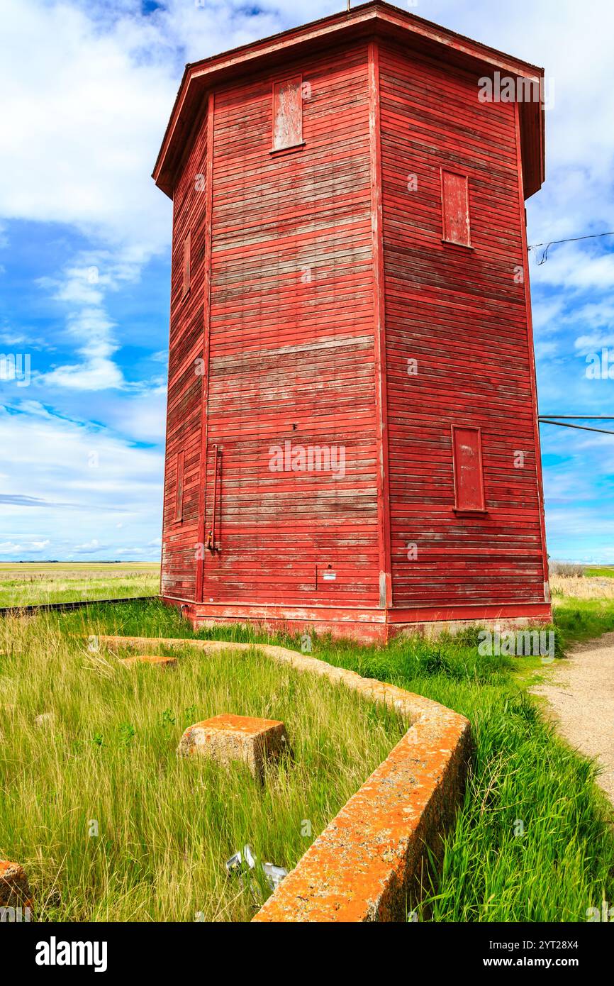 A red brick tower stands in a field with a green grassy area around it ...