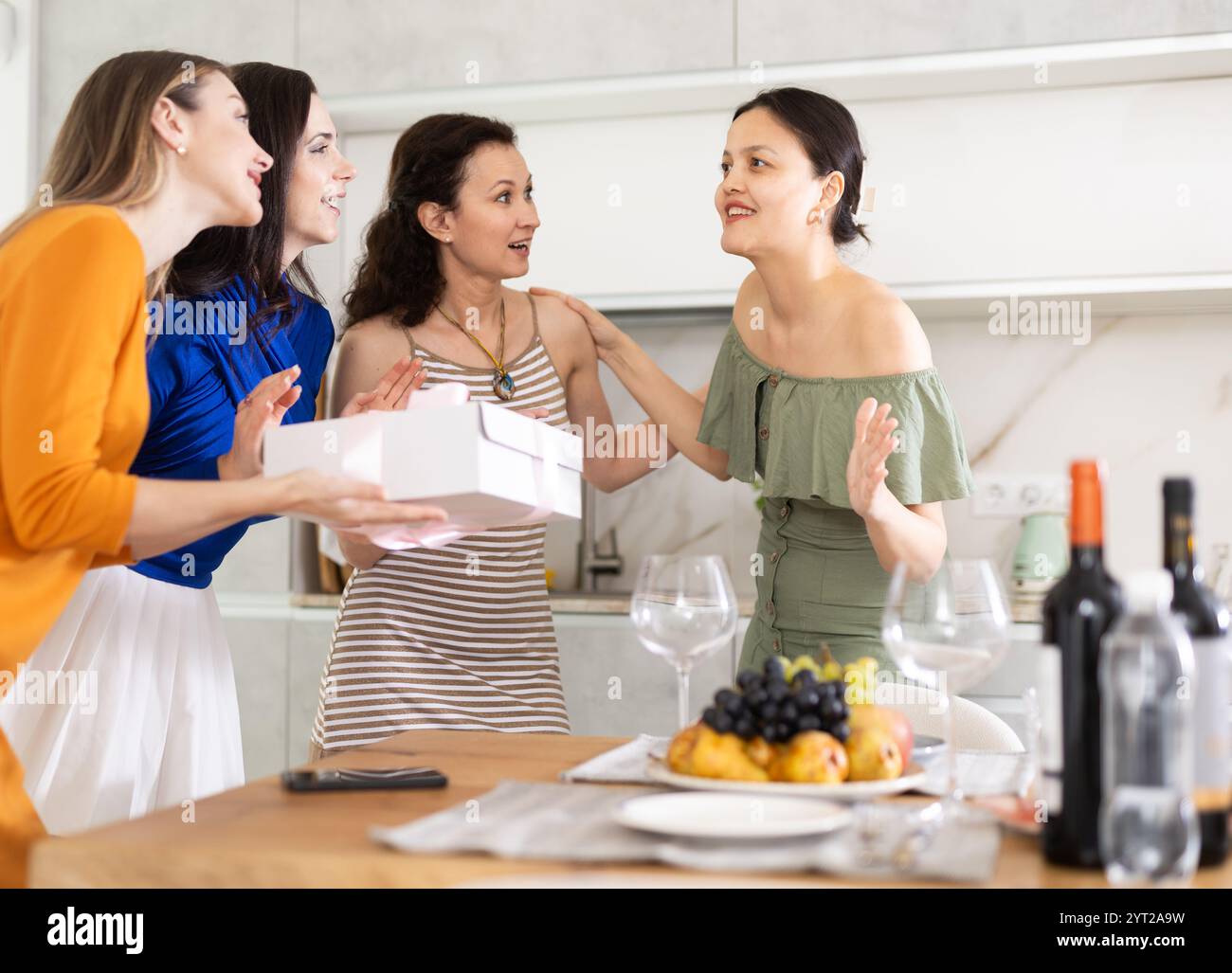 Group of women greeting each other and giving gift Stock Photo - Alamy