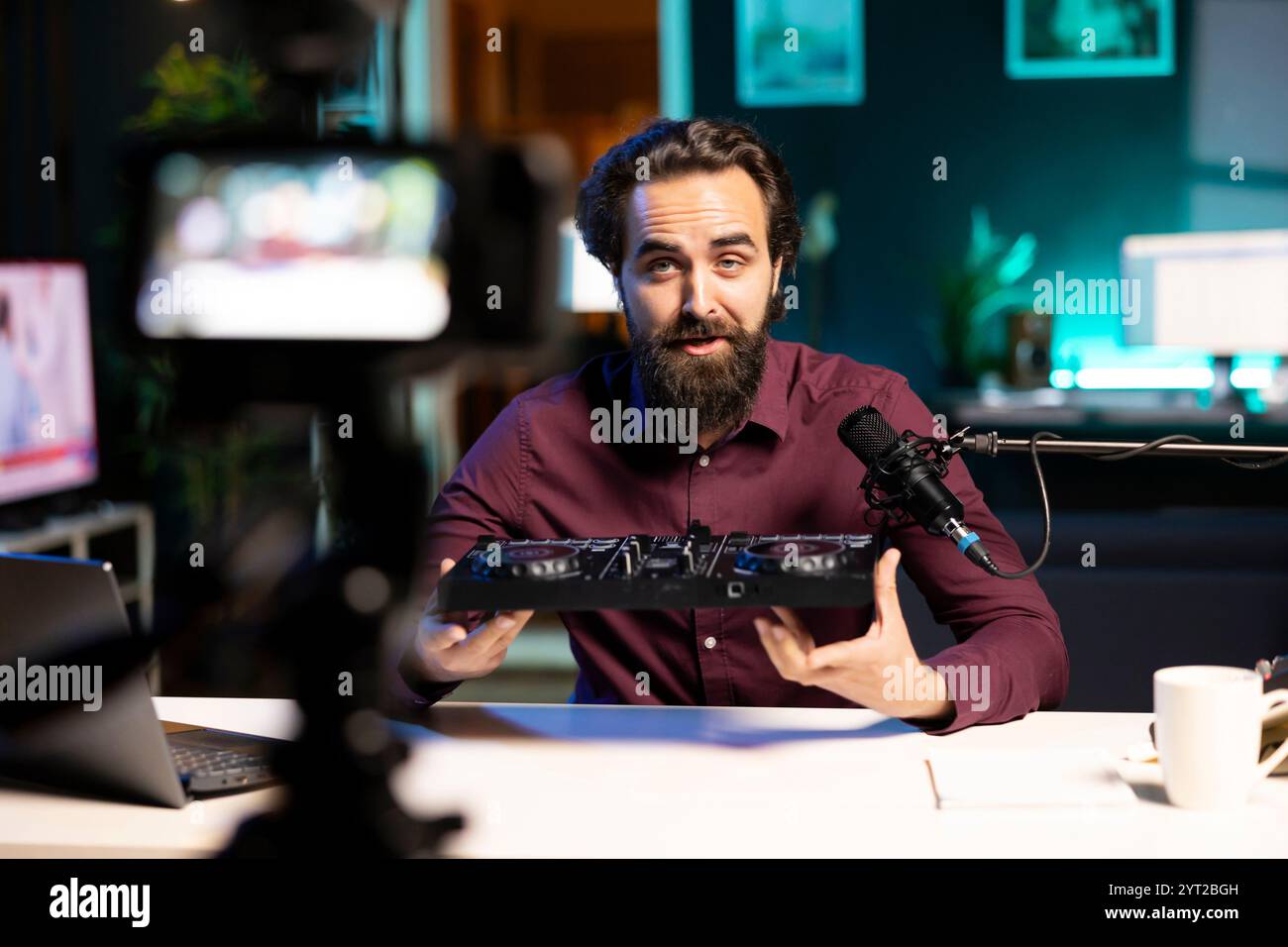 Content creator filming technology review of DJ controller using ...