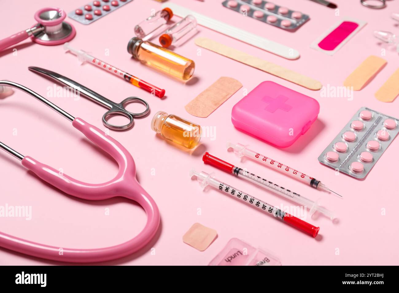 Medical supplies with stethoscope, insulin syringe and patch on pink ...