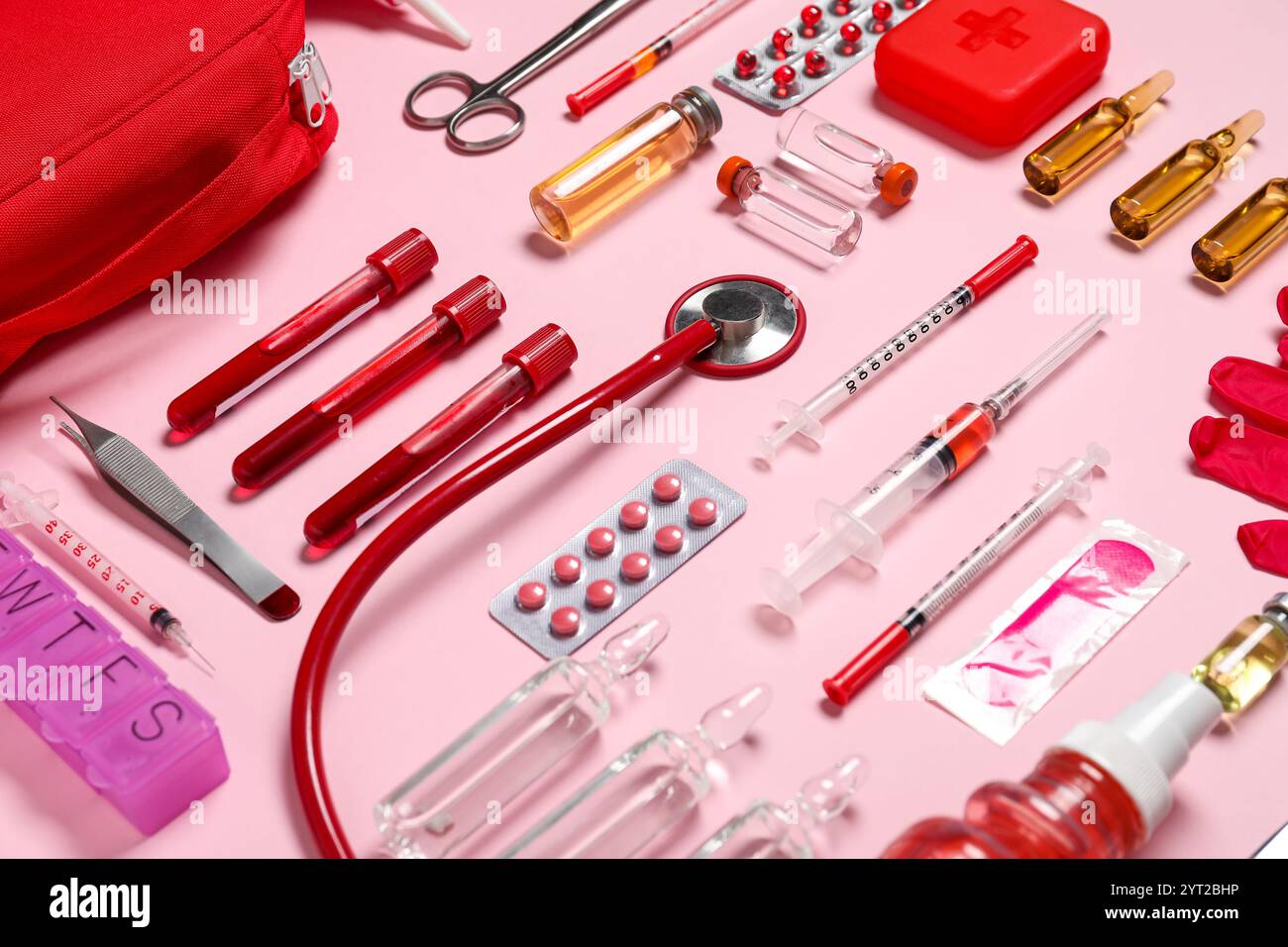Medical supplies with insulin syringe, patch and pills on pink ...