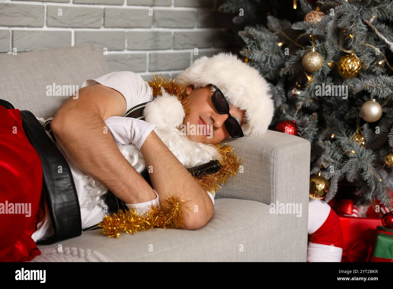 Drunk Santa Claus with bottle sleeping on sofa after party Stock Photo ...