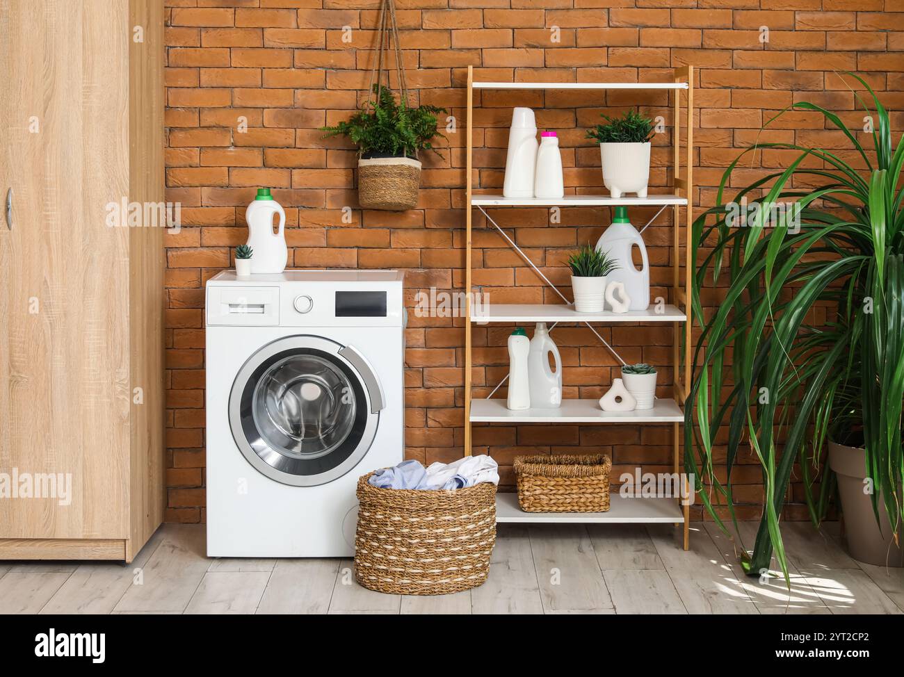 Interior of laundry room with washing machine, basket and shelf unit ...