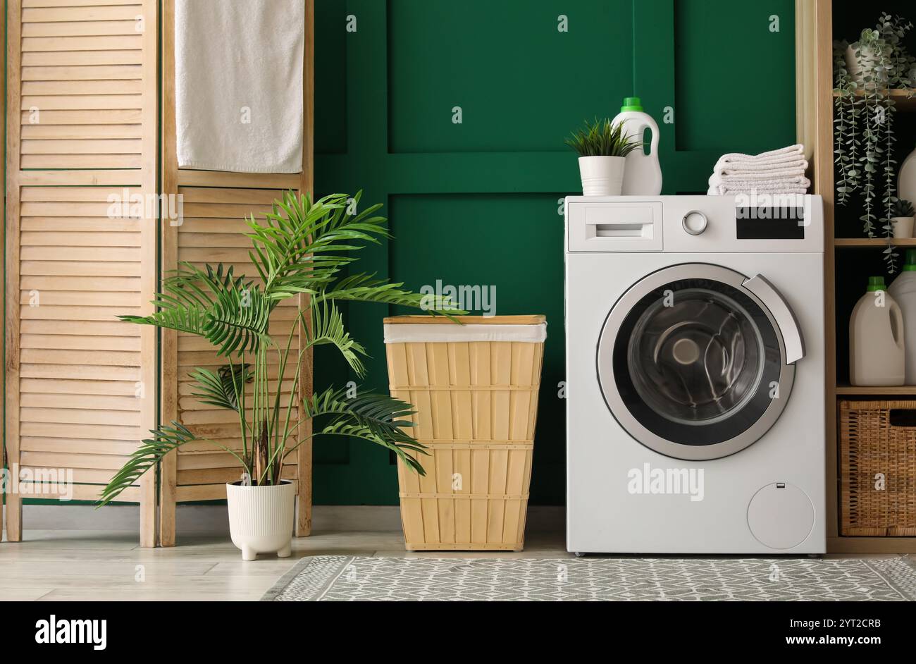 Washing machine, folding screen, and laundry basket near green wall in ...