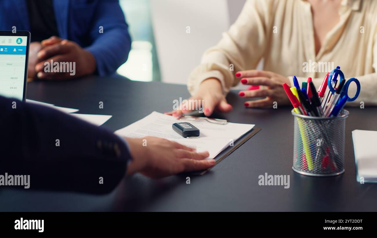 Panning shot of car dealership table with salesman and clients sitting ...