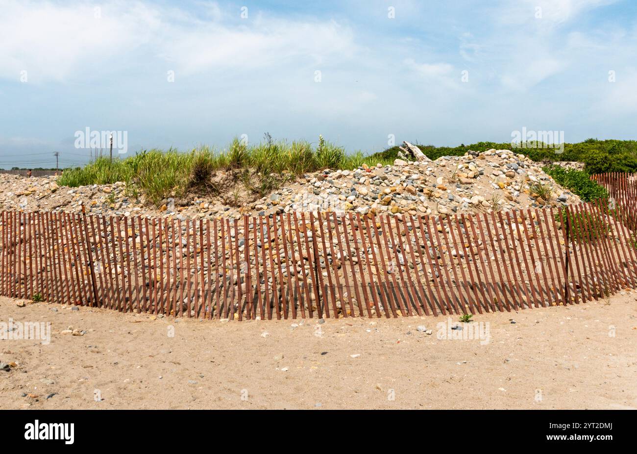 Coastal area shows a sand dune restoration project with wooden fencing ...