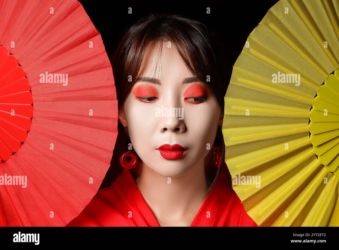 Beautiful young geisha in traditional clothes with fans on black ...