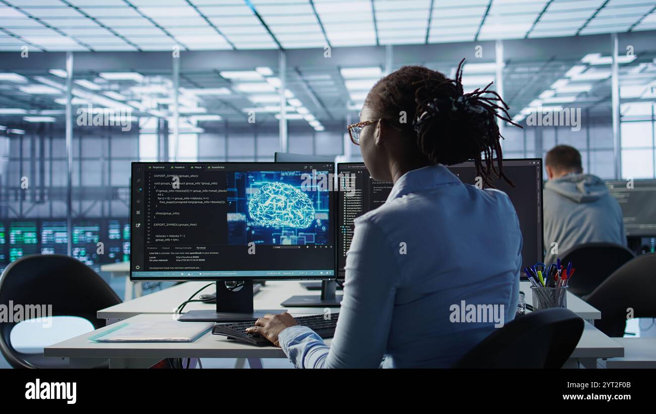 Engineer typing on computer in server hub, monitoring data center energy consumption using AI ...