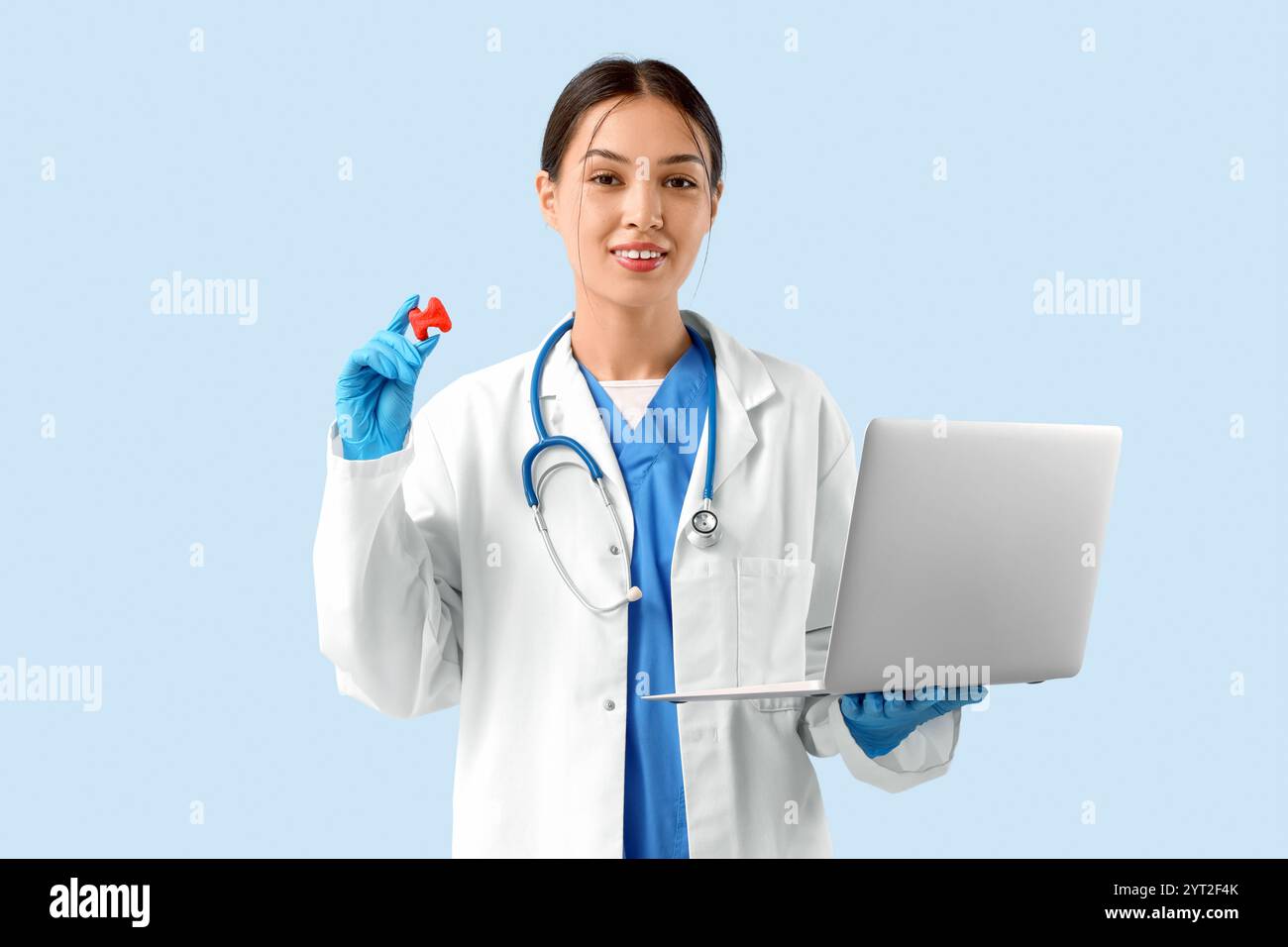 Female Asian endocrinologist with thyroid gland model and laptop on ...