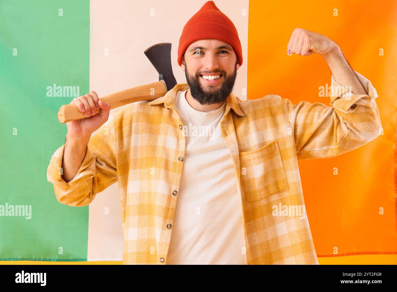 Handsome lumberjack with axe showing muscles against flag of Ireland ...