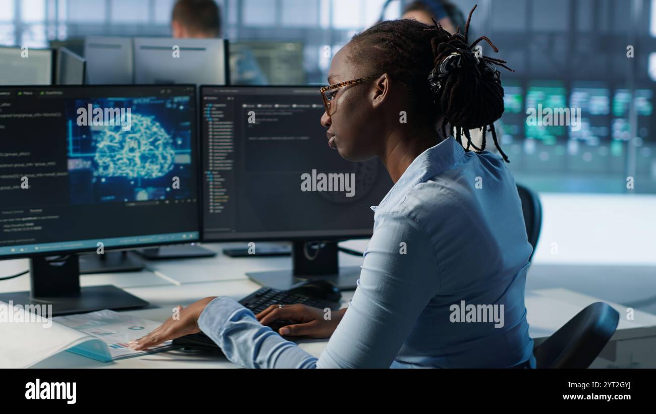 Woman leaving desk after finishing programming tasks in AI data center used for machine learning ...