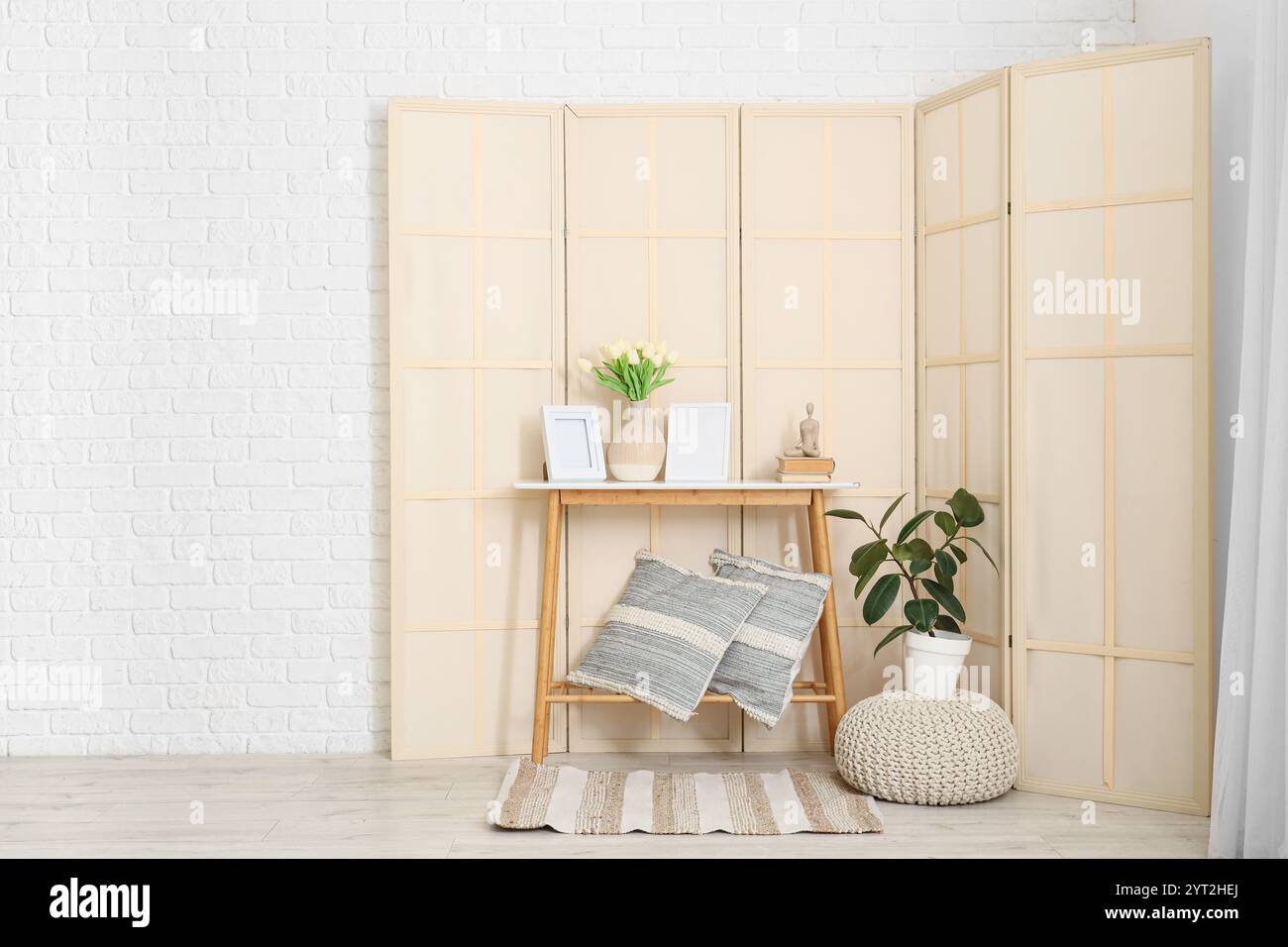 Interior of room with folding screen, table and pouf Stock Photo - Alamy