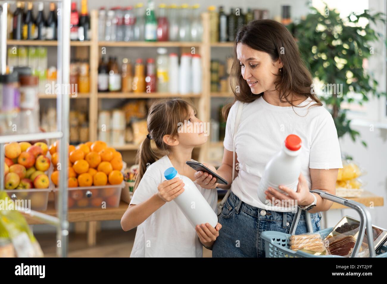 Checking expiration date of milk - mother and daughter checking qr code ...