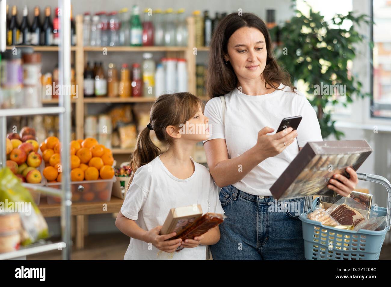 Daughter and mother choose delicious cookies in supermarket - scan QR ...