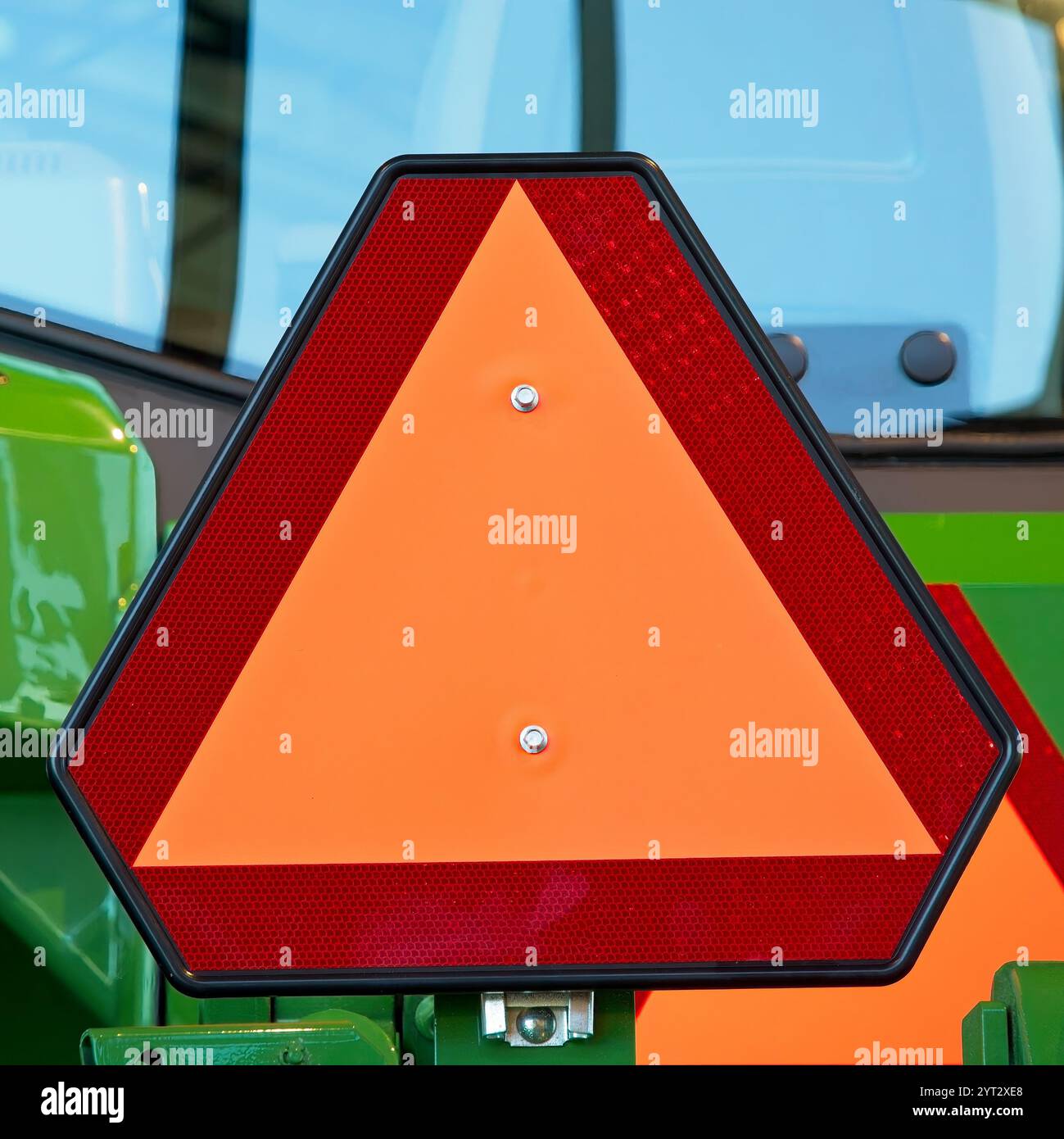 Close up orange reflective farm triangle safety sign for slow moving ...