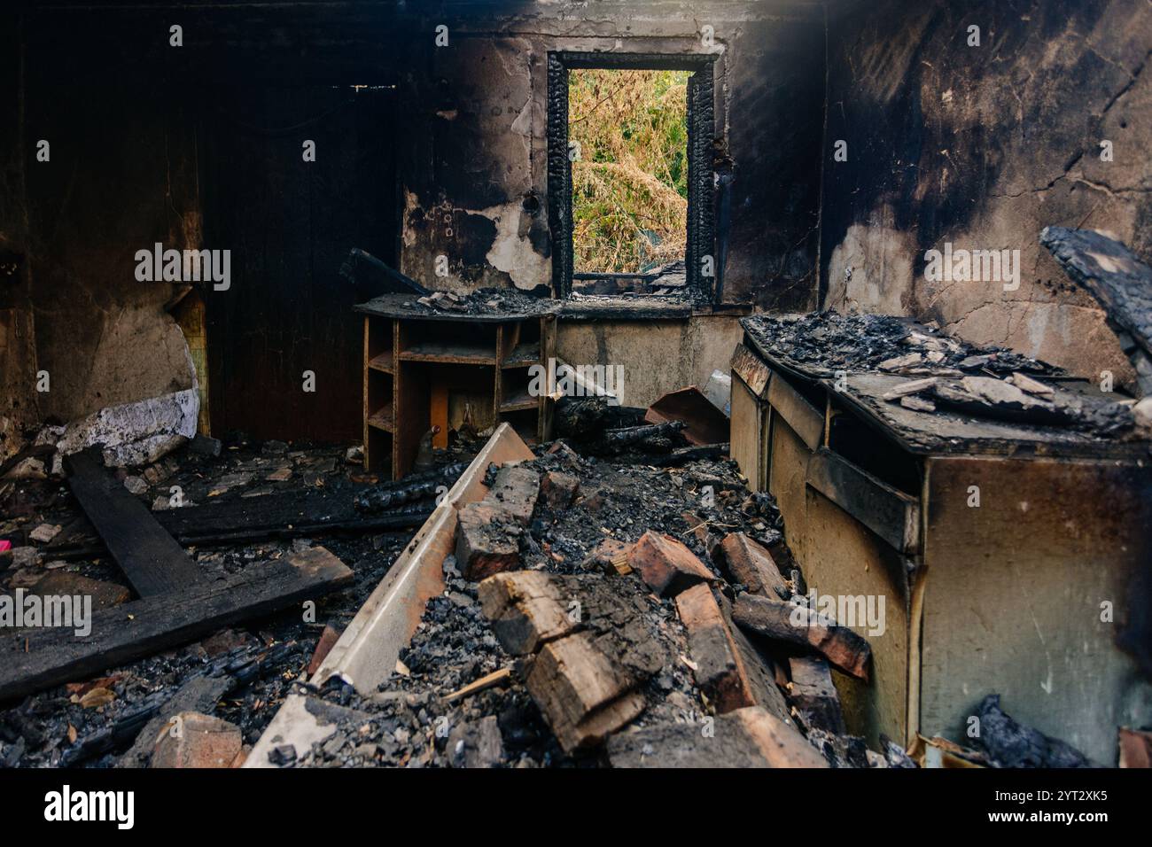Fire aftermath. Burnt wooden house interior with remnant of furniture ...