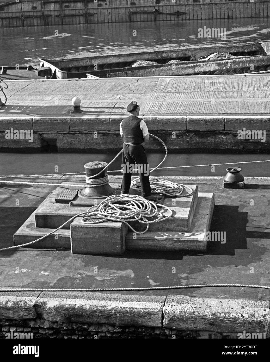 Ropeman waits to tie up barges on canal in East End ,1950's Stock Photo ...