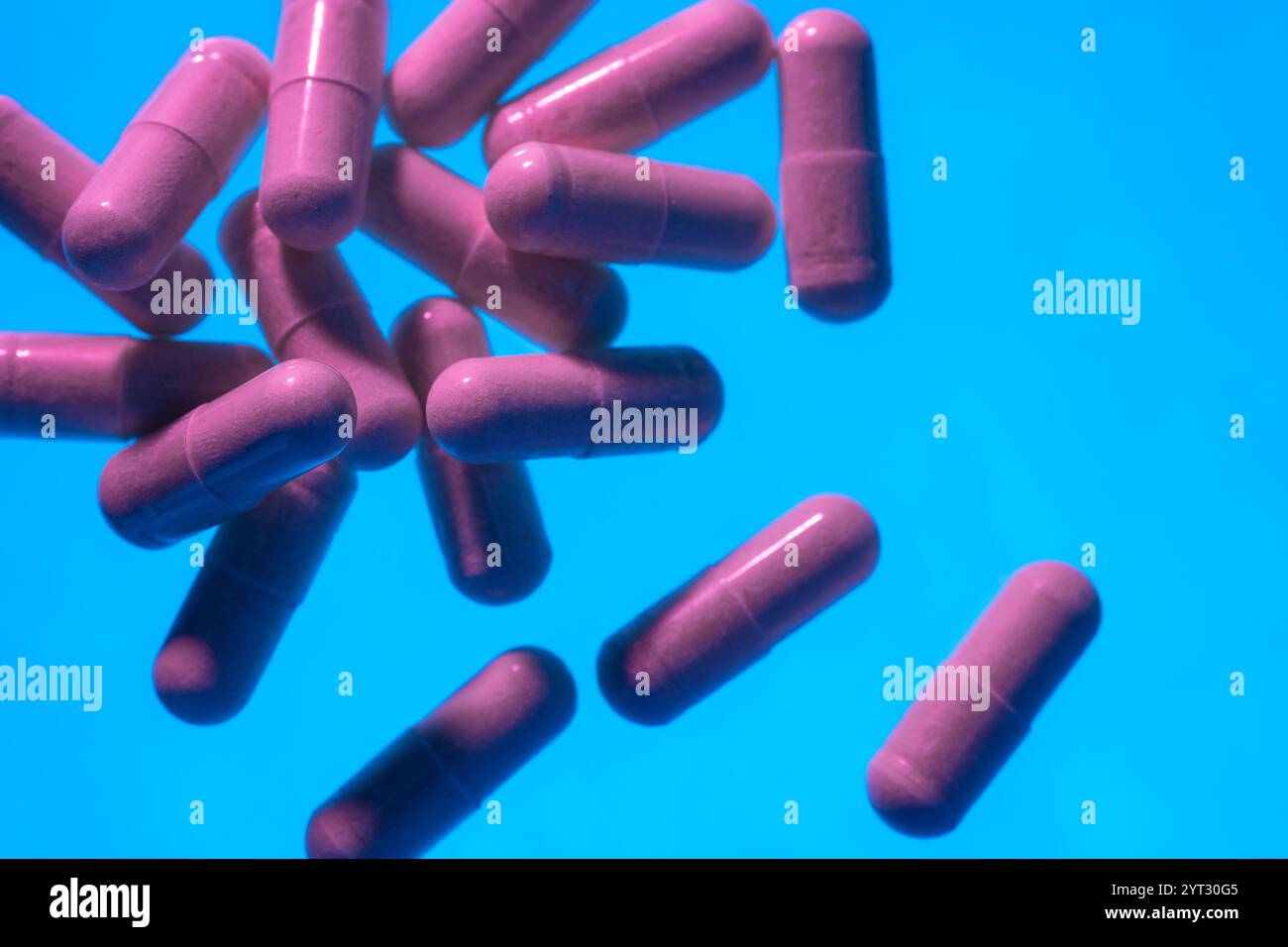 Pink Medication Capsules on Blue Background Stock Photo - Alamy