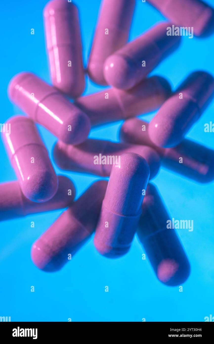 Pink Medication Capsules on Blue Background Stock Photo - Alamy
