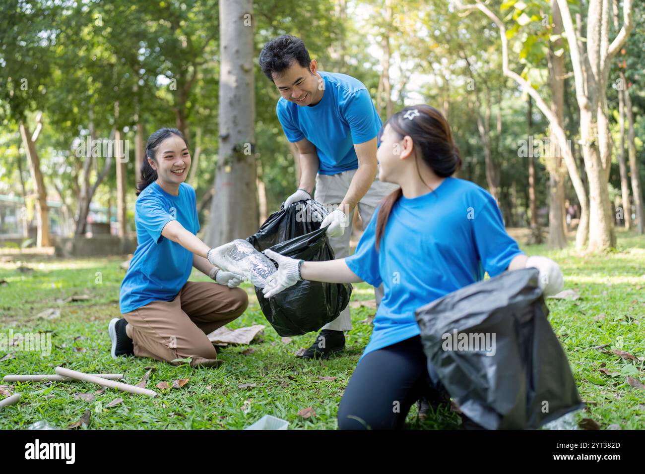 Happy Family Volunteering Together in a Park, Collecting Trash and Promoting Environmental ...