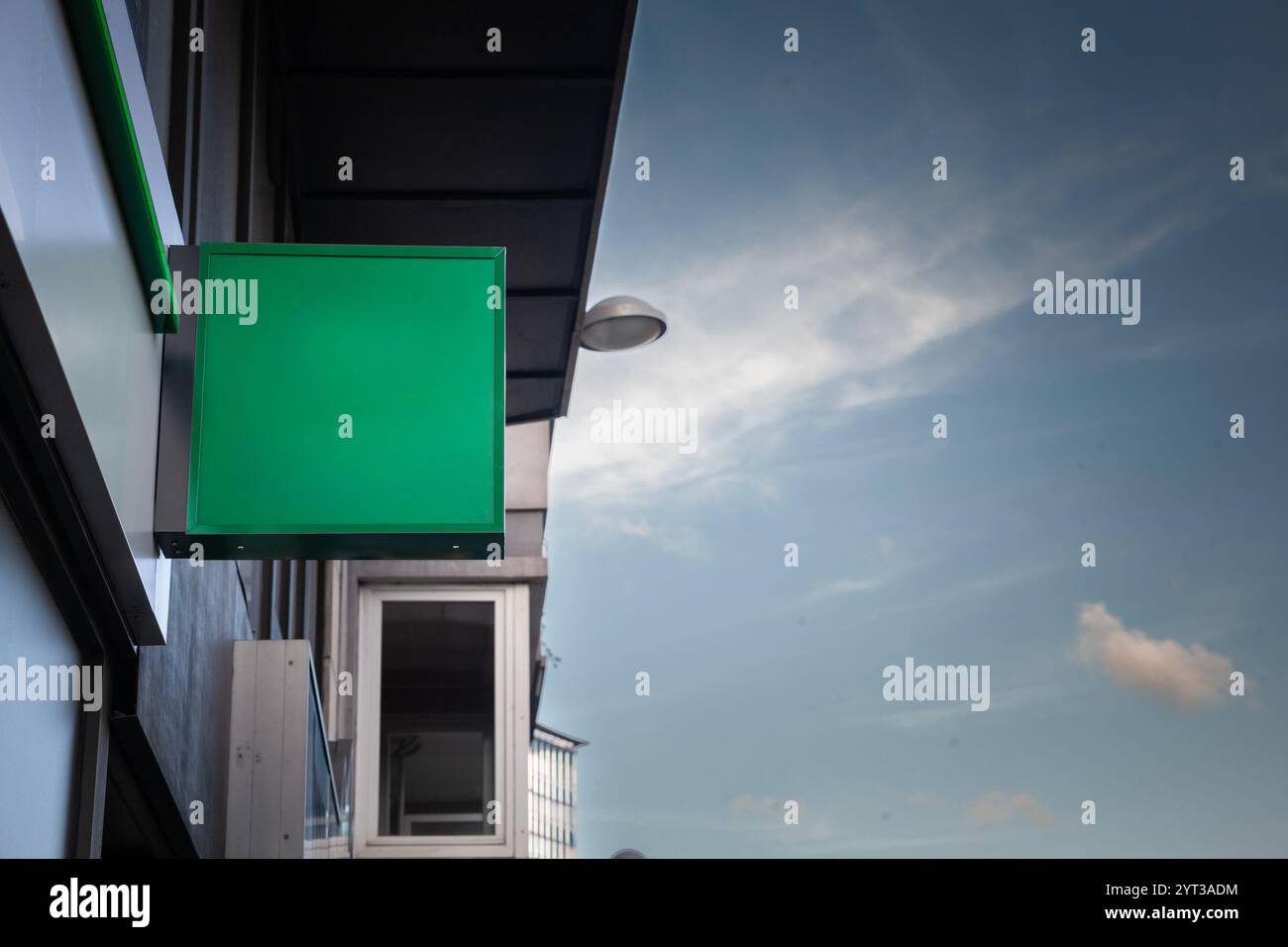 Minimalistic green signage hanging outside a Belgian storefront. A ...