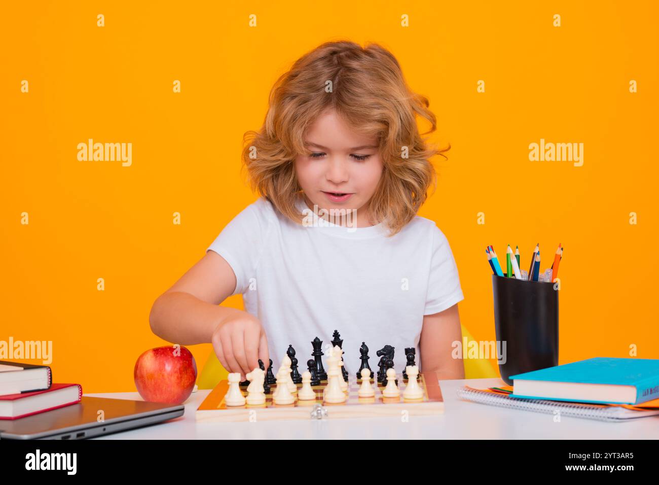Kid play chess on isolated studio background. Clever concentrated and ...