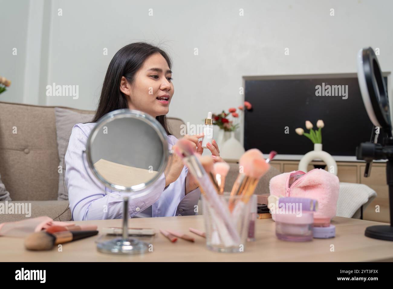 Asian beauty influencer applying makeup during video tutorial Stock ...