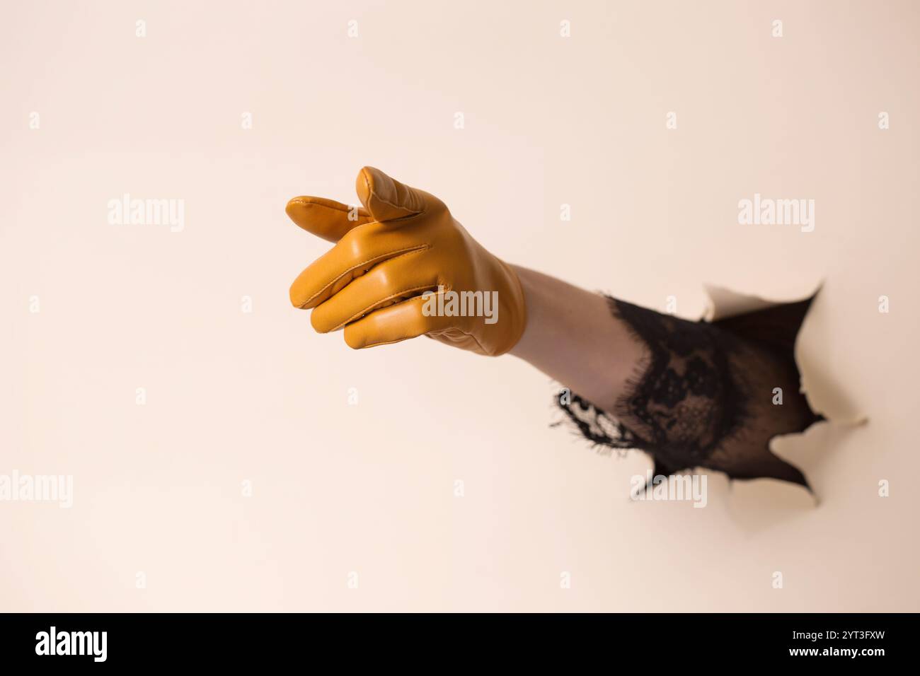 A woman's hand in a leather glove shows a gesture. The hand is pushed ...
