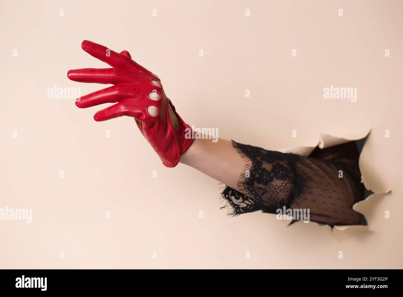 A woman's hand in a red leather car glove waving his hand. The hand is ...