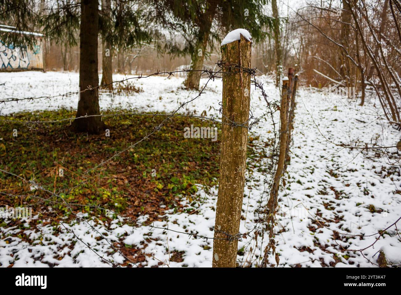 A makeshift fence made of barbed wire and posts around a closed-to ...